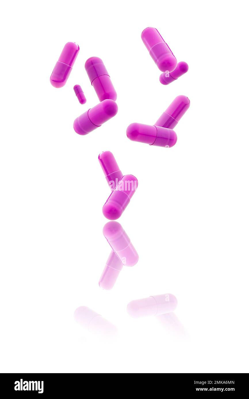 pink medical gel capsules falling down on white background. food ...