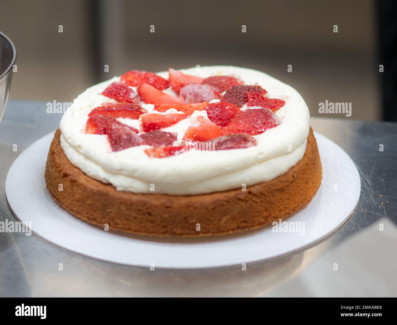 chef pastry designer confectioning a frosted 3 floor layered cake ...