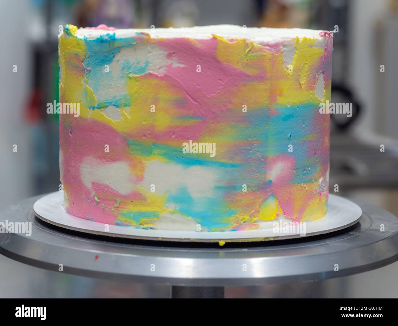 chef pastry designer confectioning a frosted 3 floor layered cake ...