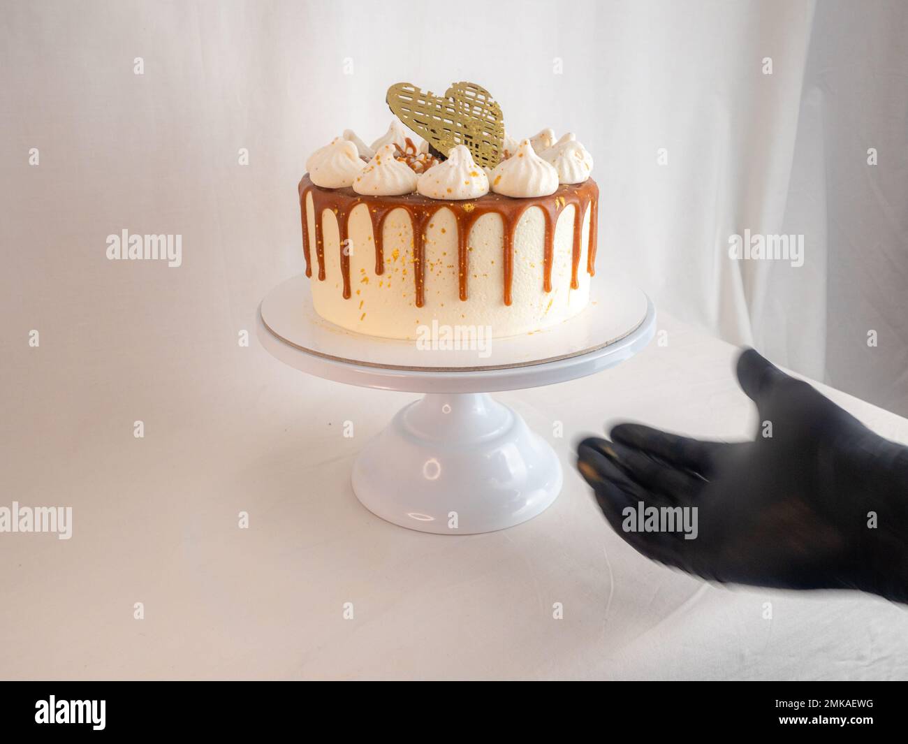 chef pastry baker finishing salty caramel frosted dripping cakes with ...