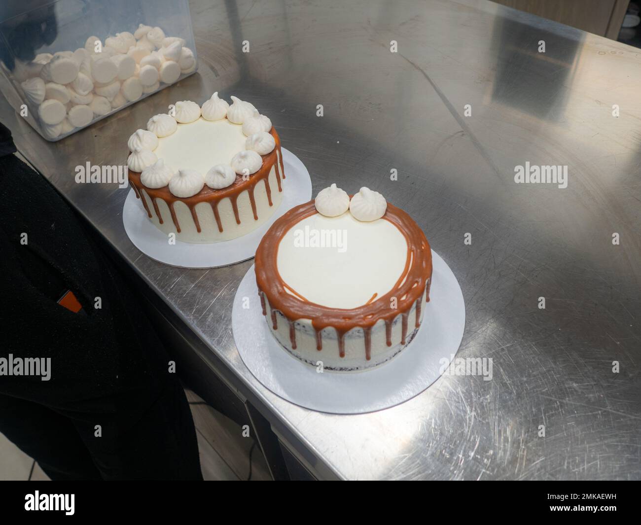 chef pastry baker preparing salty caramel frosted dripping white cakes ...