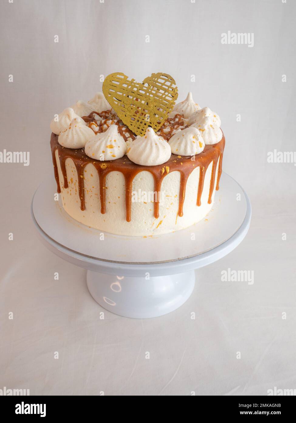 chef pastry baker finishing salty caramel frosted dripping cakes with ...