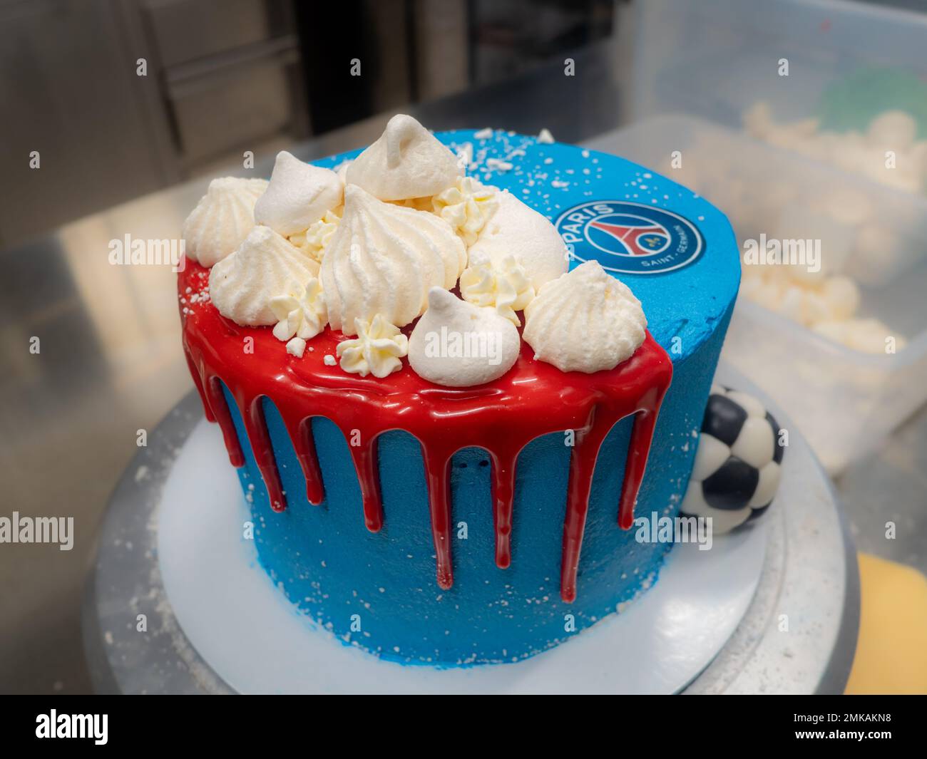 blue sprayed frosted cake on stand dripped with red ganache filling and ...