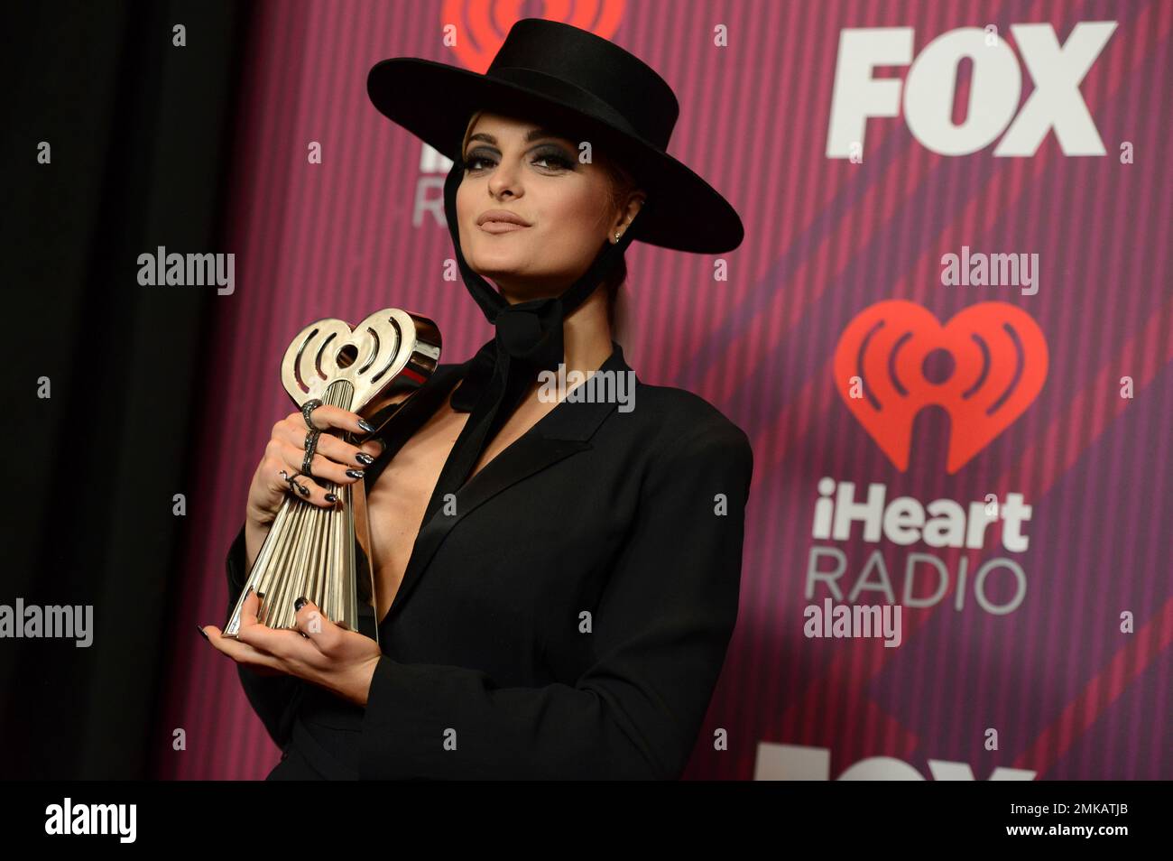 Bebe Rexha poses in the press room with the award for country song of ...