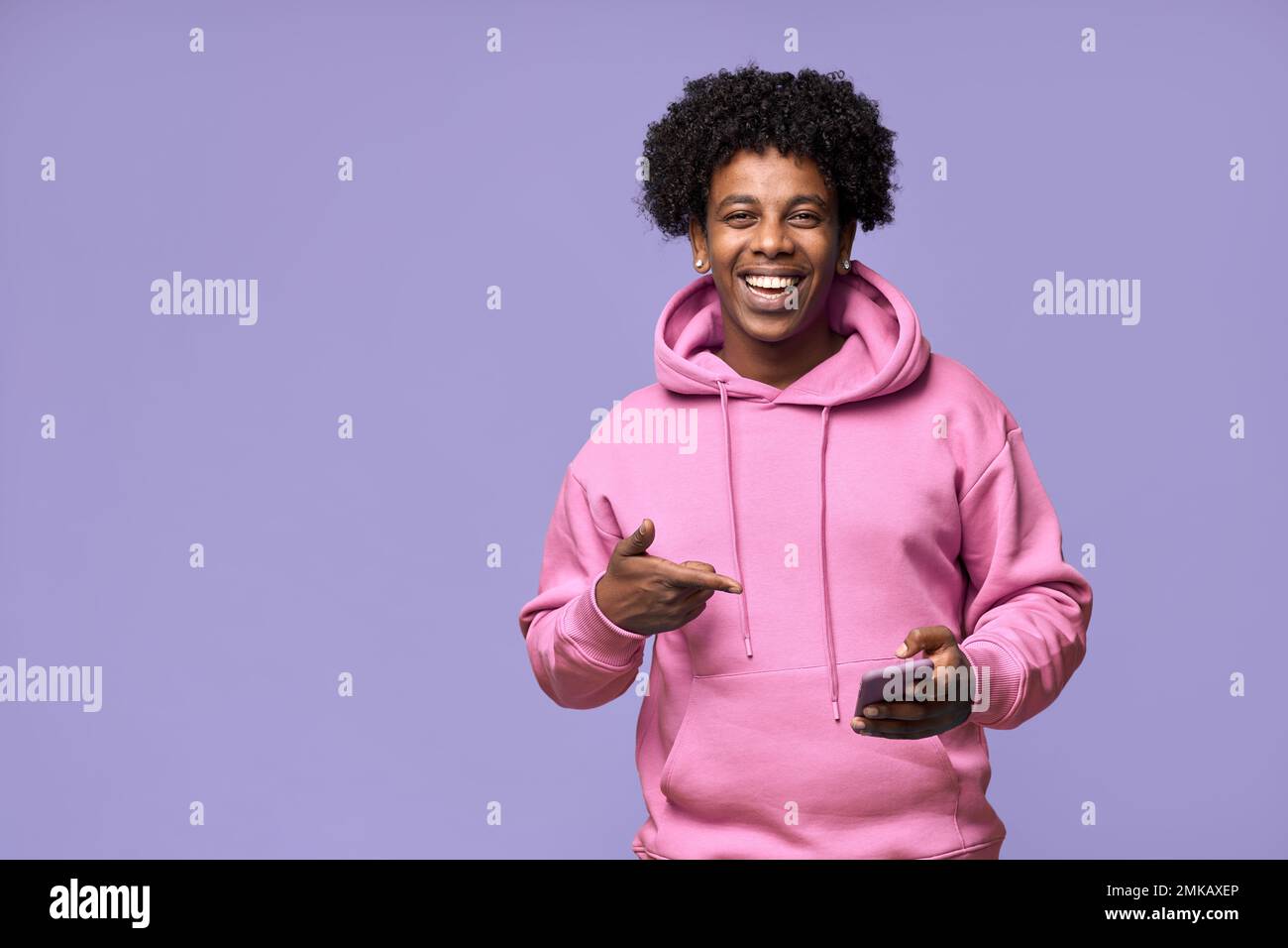Happy African teen boy using cell phone pointing at mobile isolated on ...