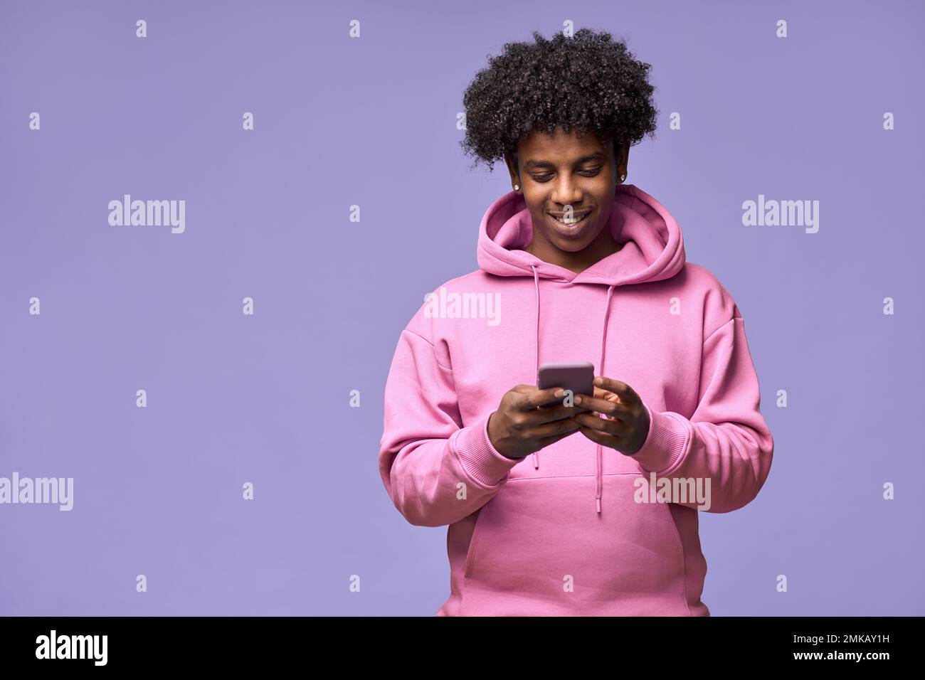 Happy African teen guy holding cell phone using mobile apps isolated on ...