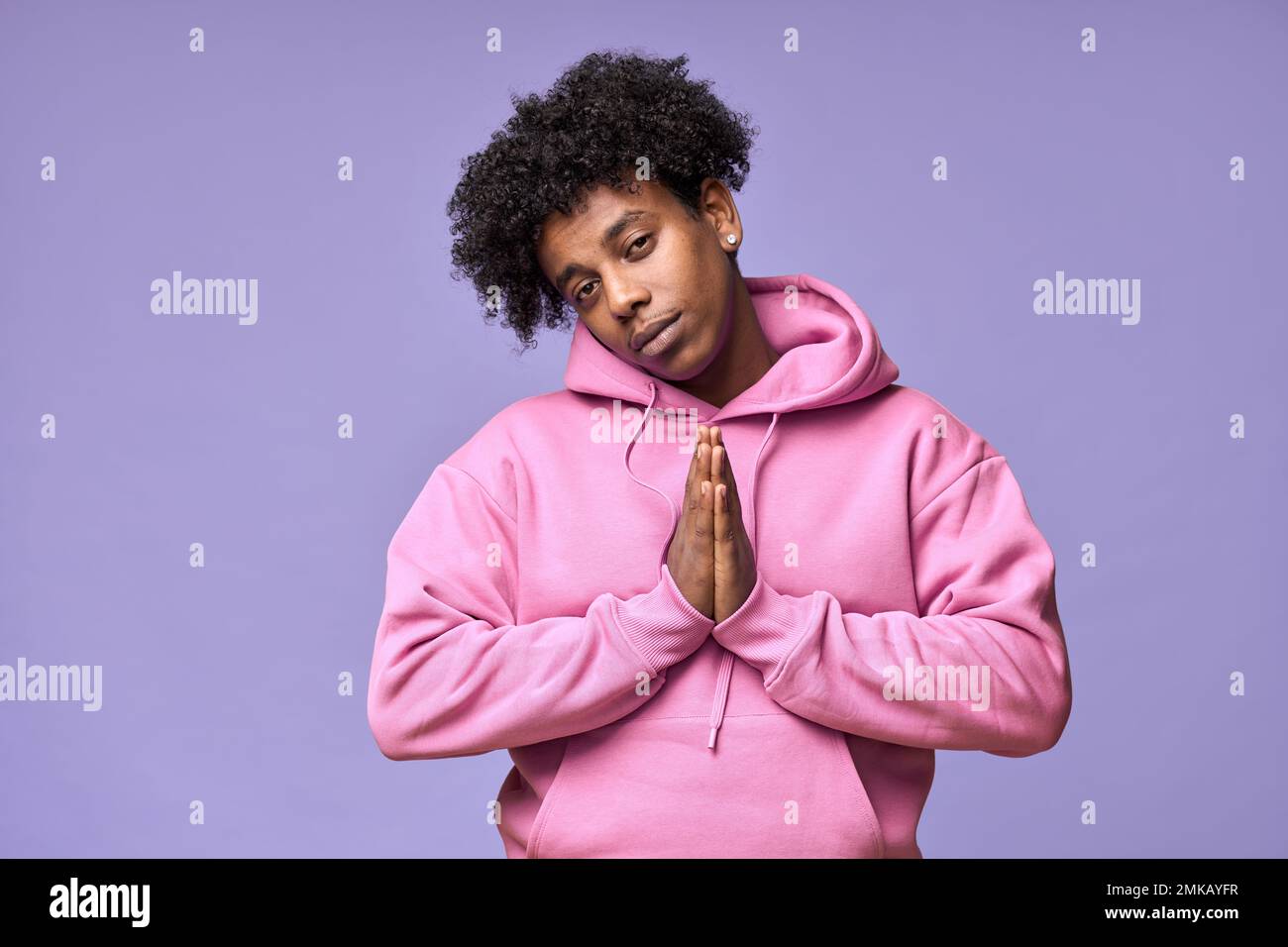 Cunning African American teen guy holding hands together asking please ...