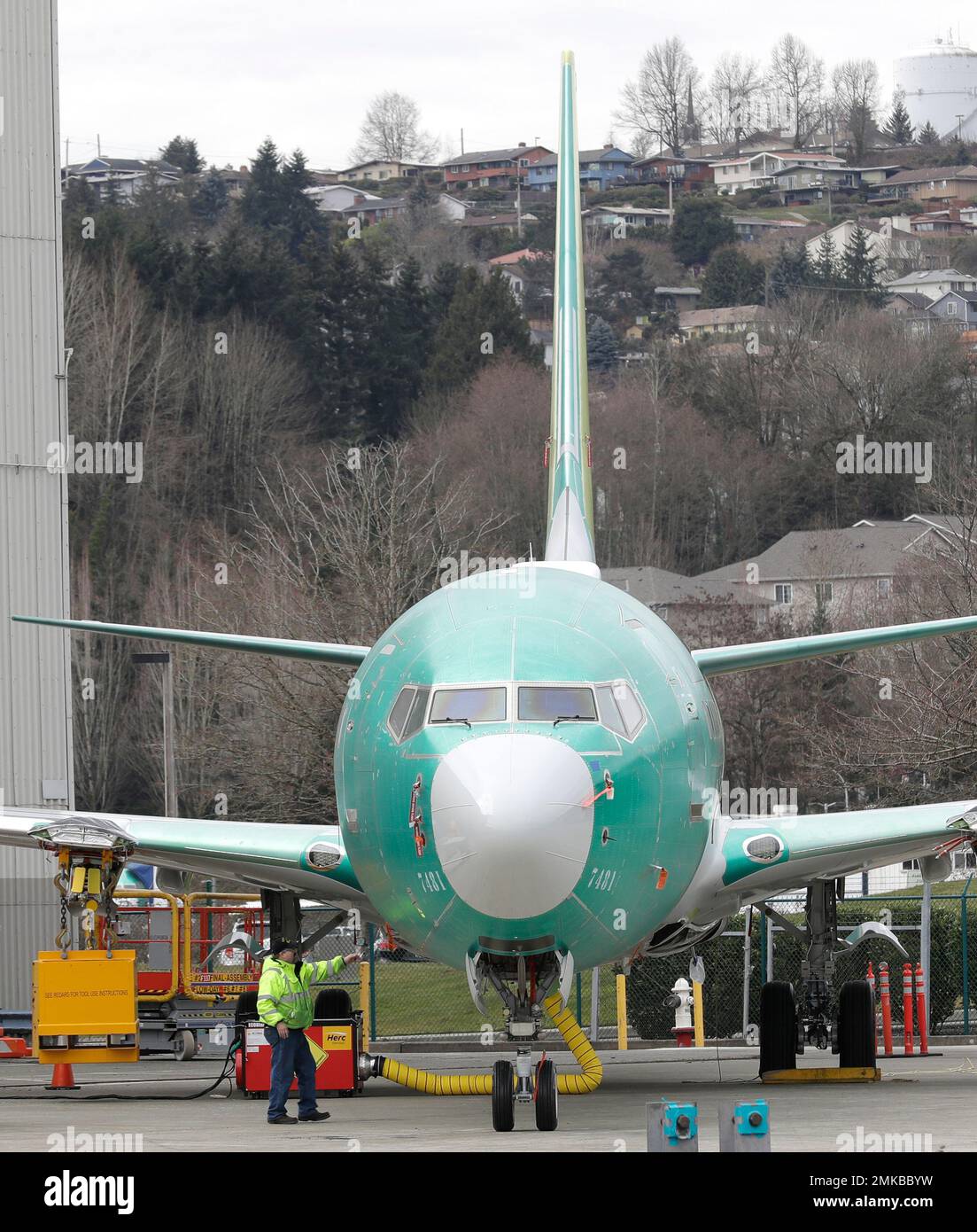 A worker stands near a Boeing 737 MAX 8 airplane parked at Boeing Co.'s ...