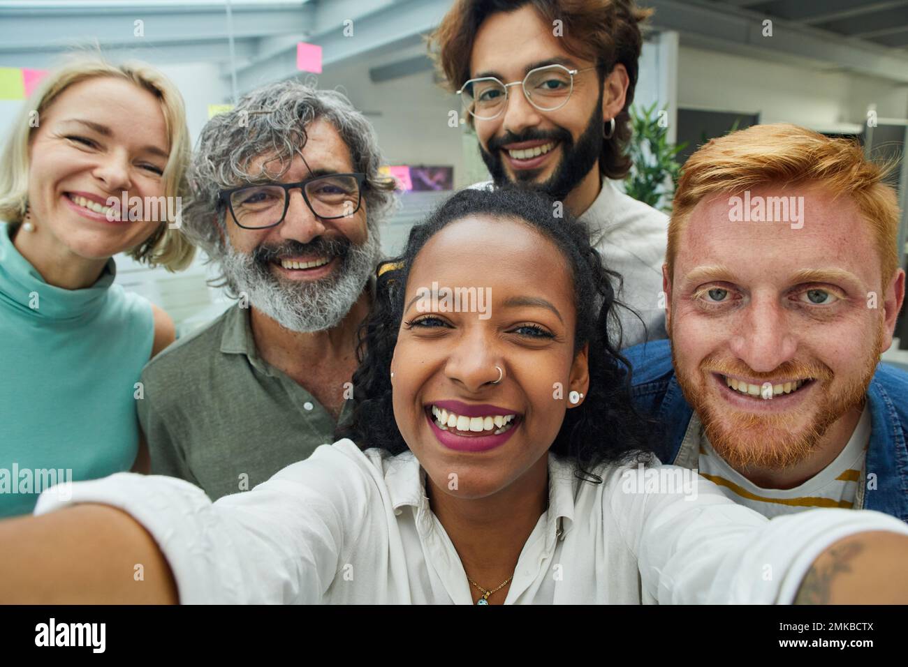 Colleagues looking at the camera taking selfie with cheerful expression ...