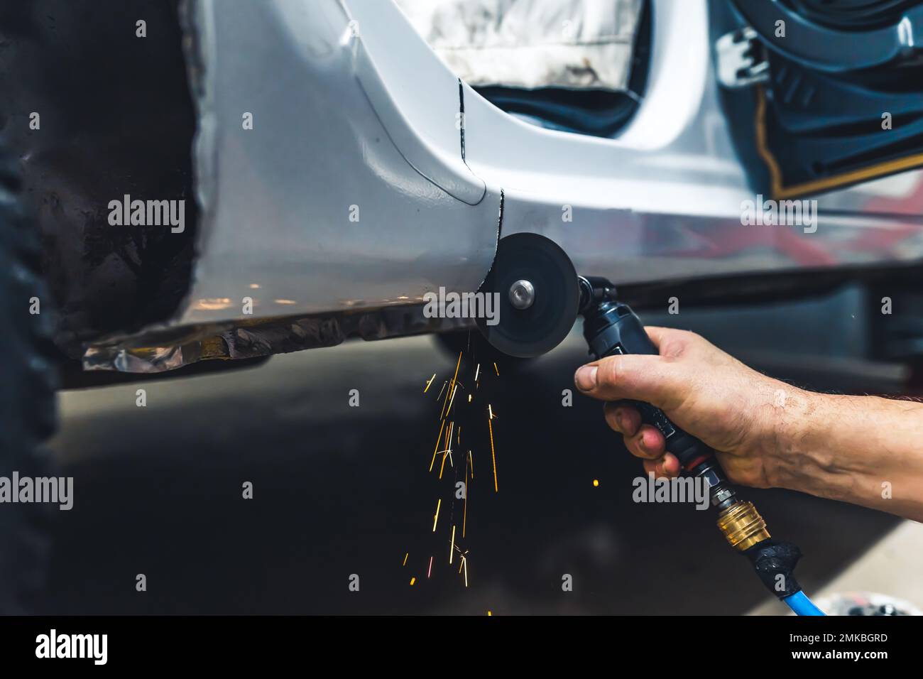 Close-up of male hand holding small rotary saw tool cutting out ...