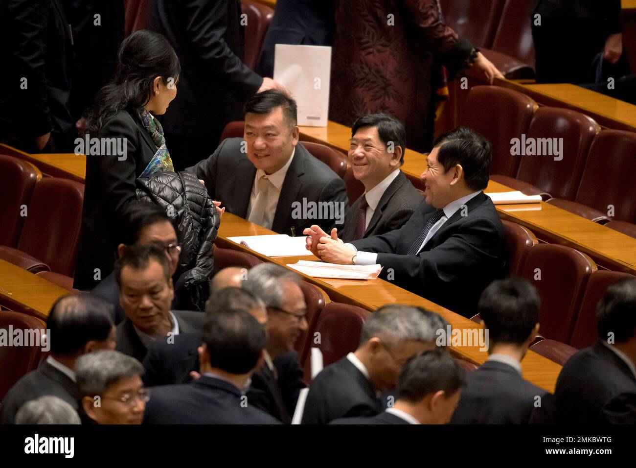 Delegates talk as others leave after a plenary session of the Chinese ...