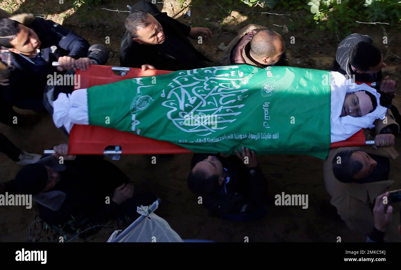 Relatives carry the body of Saif Abu Zaied, 15, into his family house ...