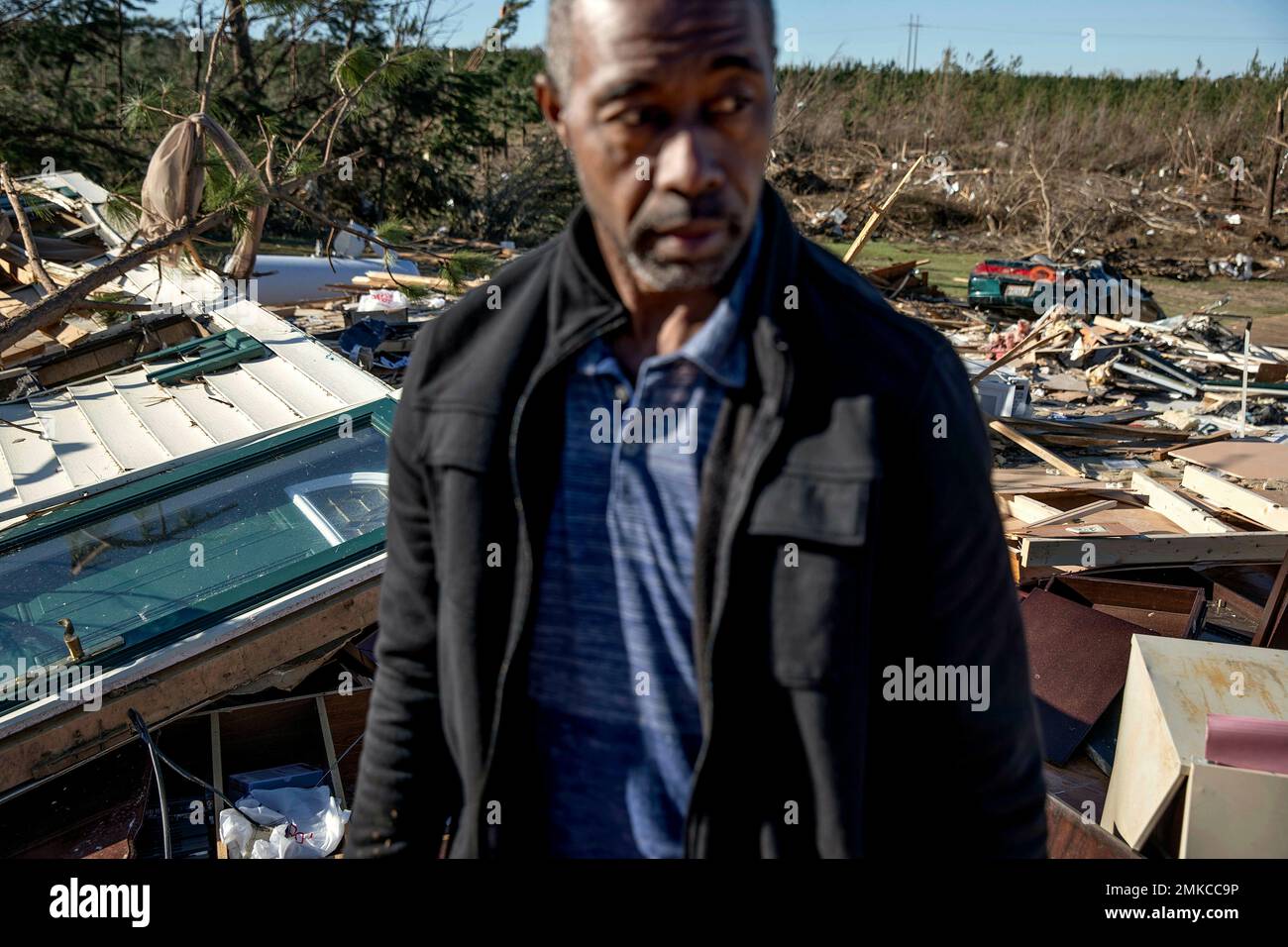 Richard Tate stands amid what's left of his home where he survived a ...