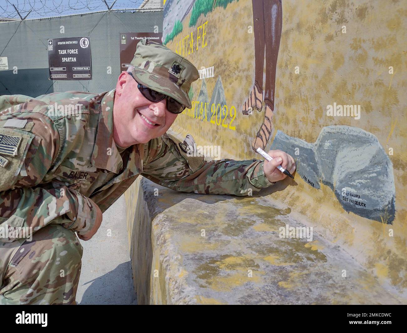 U.S. Army Soldier Lt. Col. Mark Bauer signs his name on a T-Wall on ...