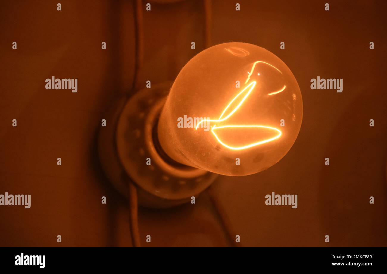 Lit lightbulb with an old fashioned style filament glowing Stock Photo ...