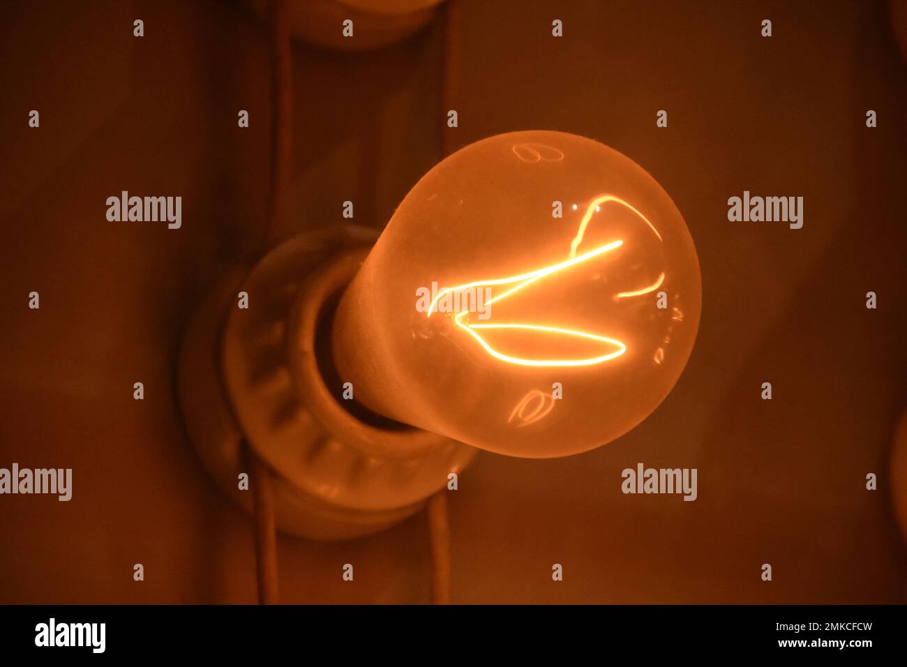 Electrical current flowing through a filament in an old style lightbulb ...