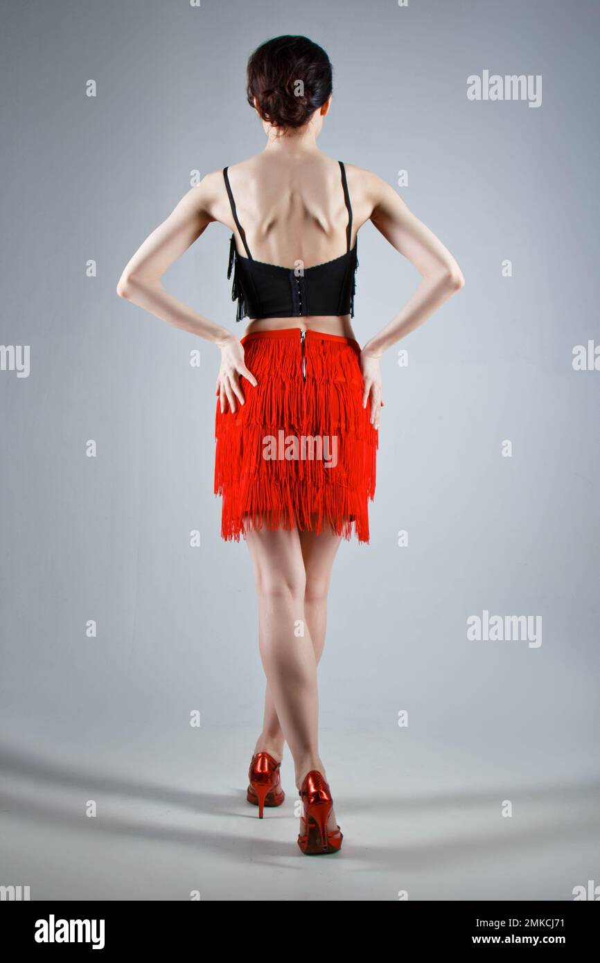 An elegant dancer performs a Latin American dance in an elegant red ...