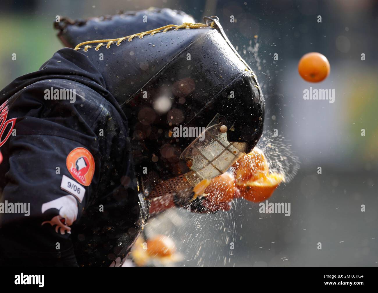 People wearing protective helmets and costumes throw and are hit by ...