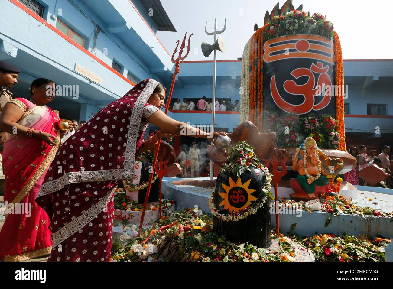 Indian devotees perform rituals on a shivling, an idol symbolic of ...