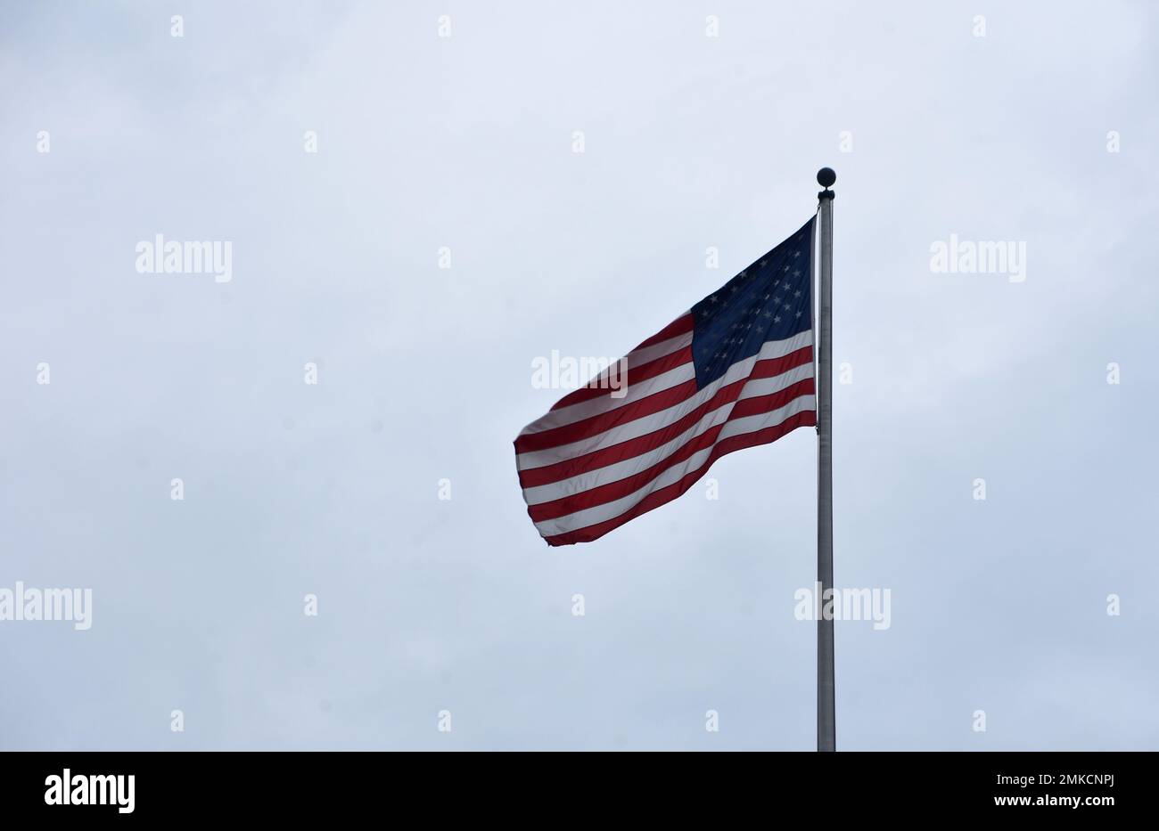 Flag blowing in the wind hanging on a flag pole in the US Stock Photo ...