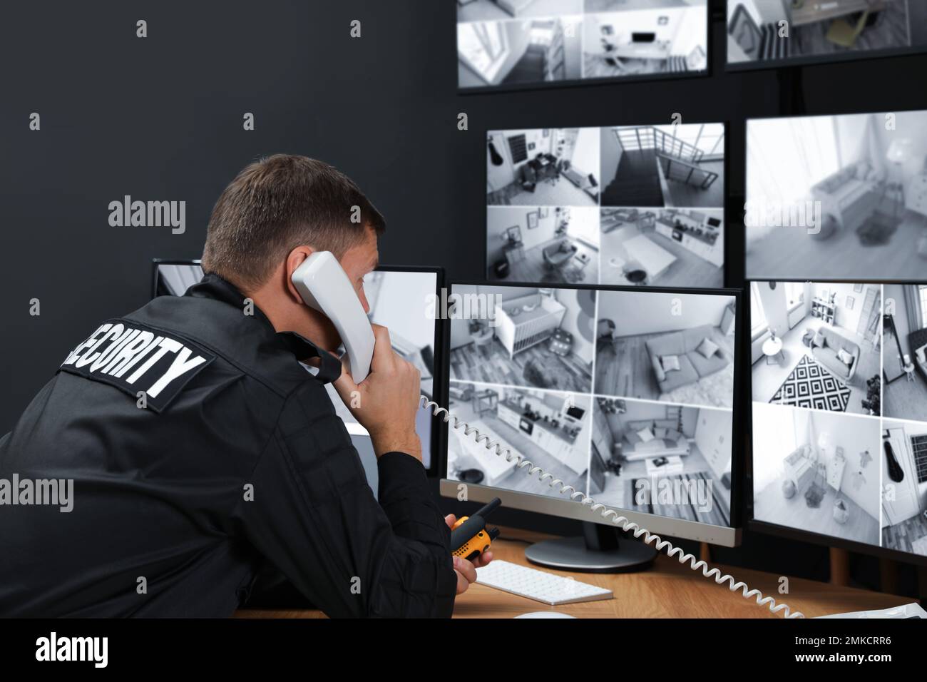 Security guard talking on telephone at workplace Stock Photo - Alamy