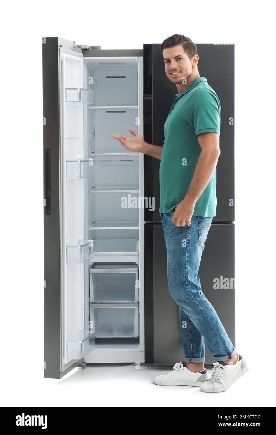 Man near empty refrigerator on white background Stock Photo - Alamy