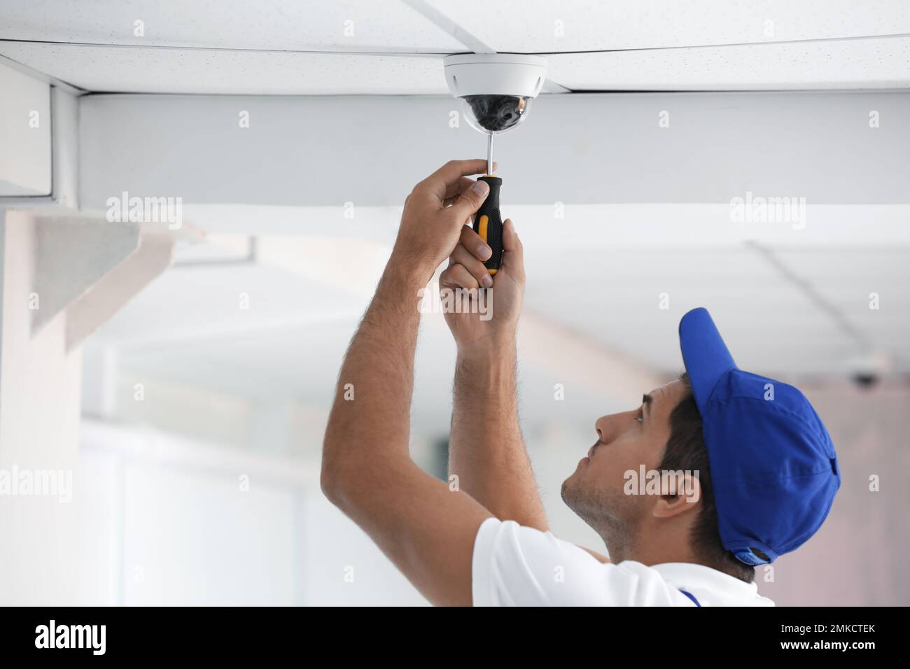 Technician installing CCTV camera on ceiling indoors Stock Photo - Alamy