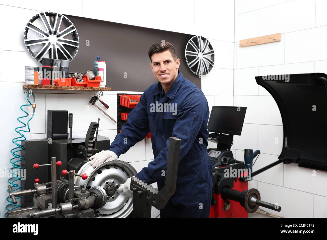 Man working with car disk lathe machine at tire service Stock Photo - Alamy