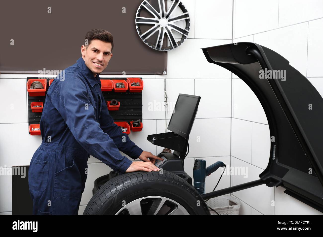 Man working with wheel balancing machine at tire service Stock Photo ...