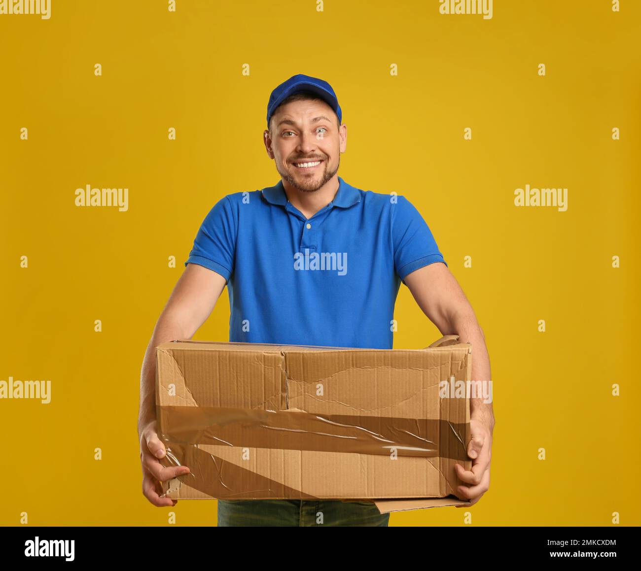 Courier with damaged cardboard box on yellow background. Poor quality ...