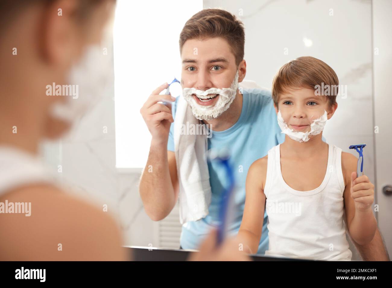 Dad shaving and son imitating him in bathroom Stock Photo - Alamy