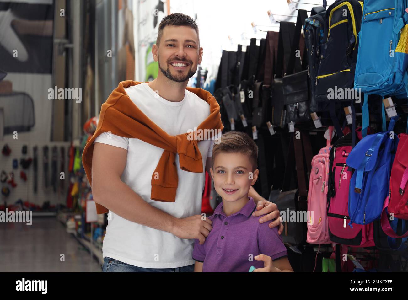 Little school boy with father choosing backpack in supermarket Stock ...