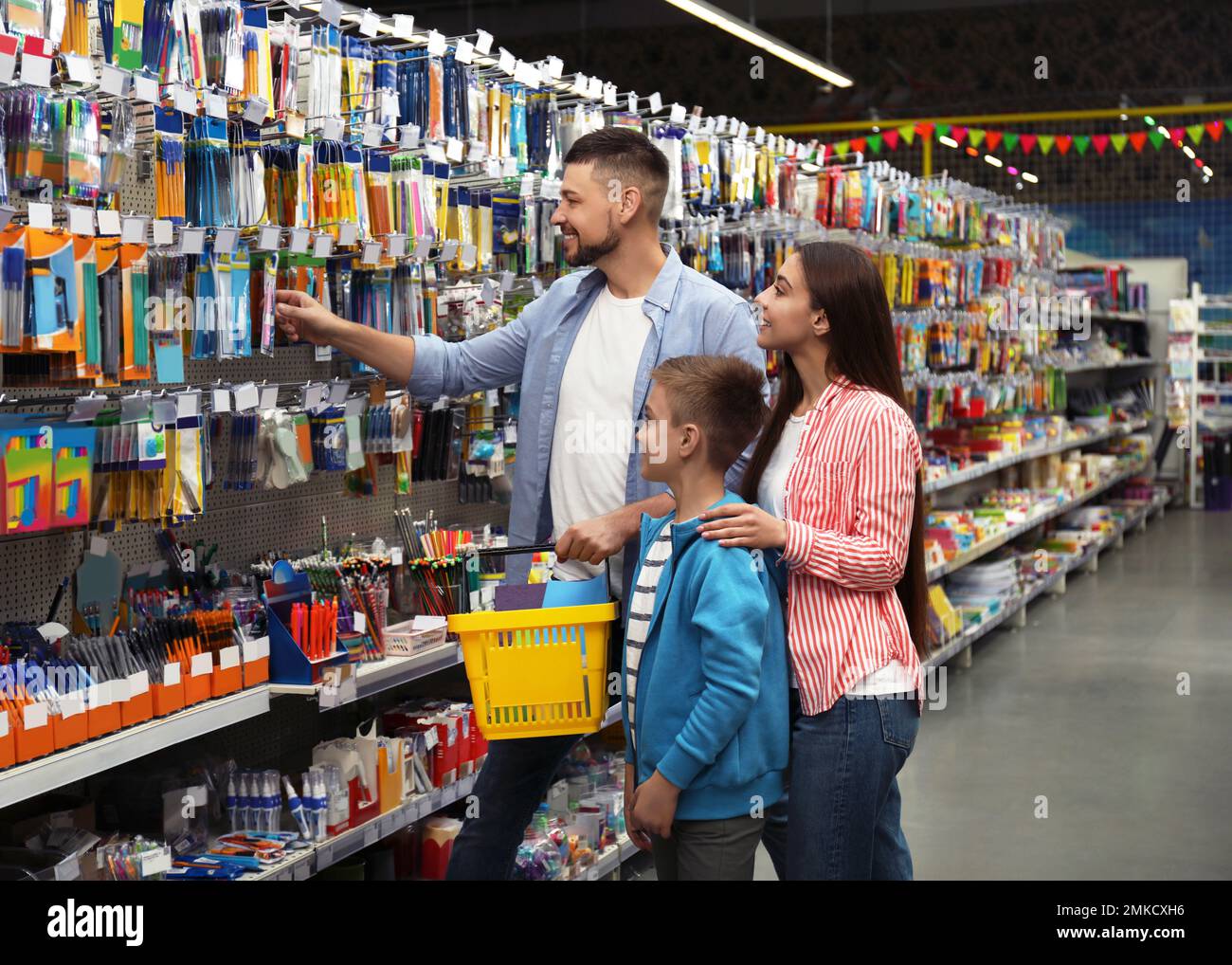 Family with little boy choosing school stationery in supermarket Stock ...