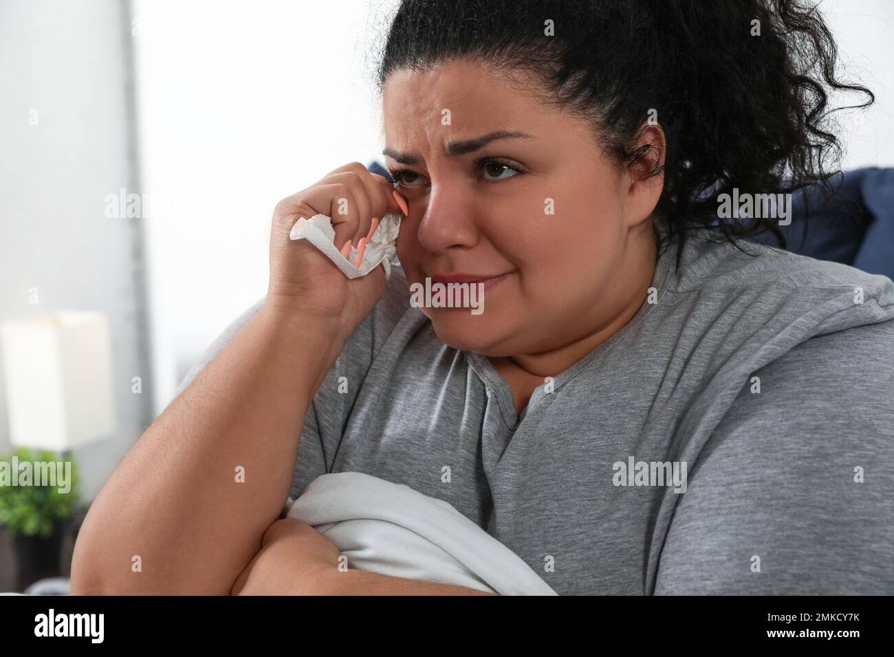 Overweight woman suffering from depression at home Stock Photo - Alamy