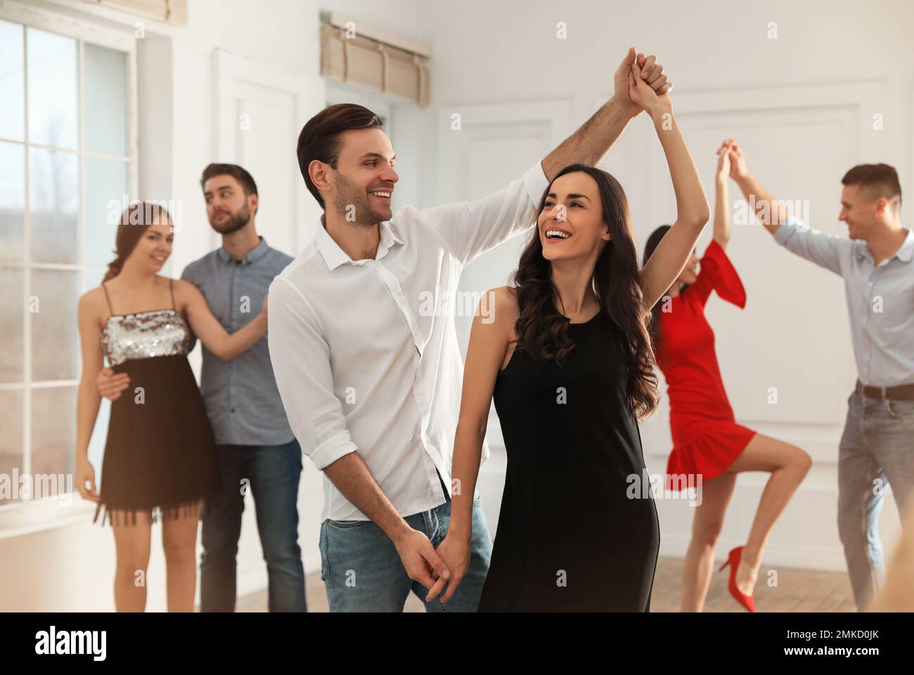 Lovely young couple dancing together at party Stock Photo - Alamy