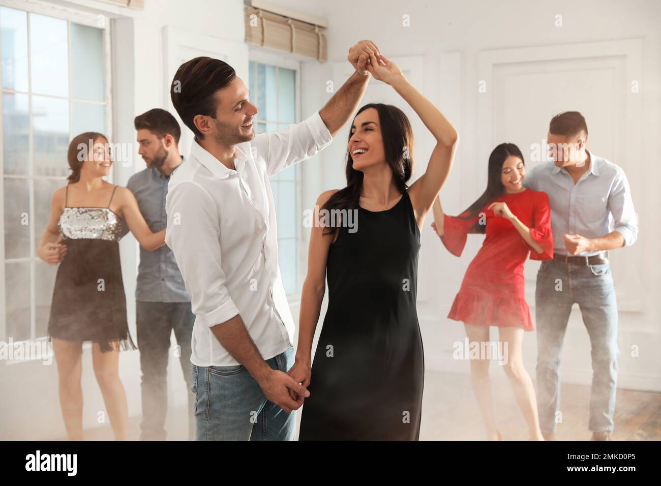 Lovely young couple dancing together at party Stock Photo - Alamy