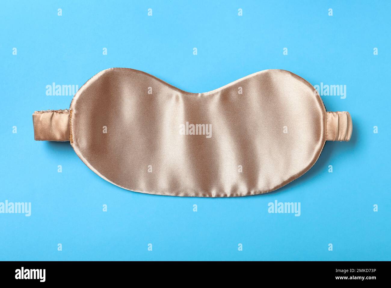 Beige sleeping mask on light blue background, top view. Bedtime ...