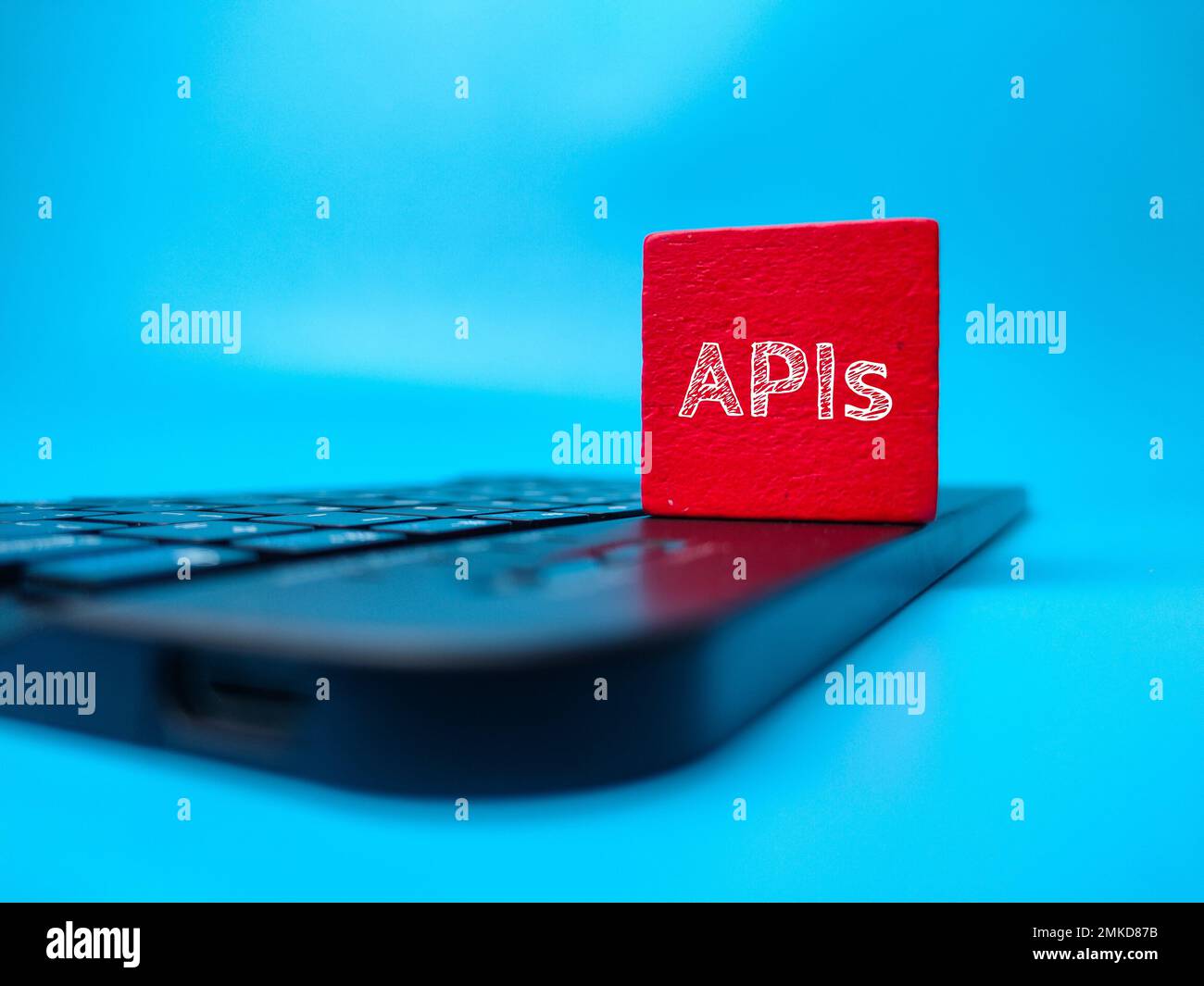 Red block and black keyboard with the word APIs on blue background ...