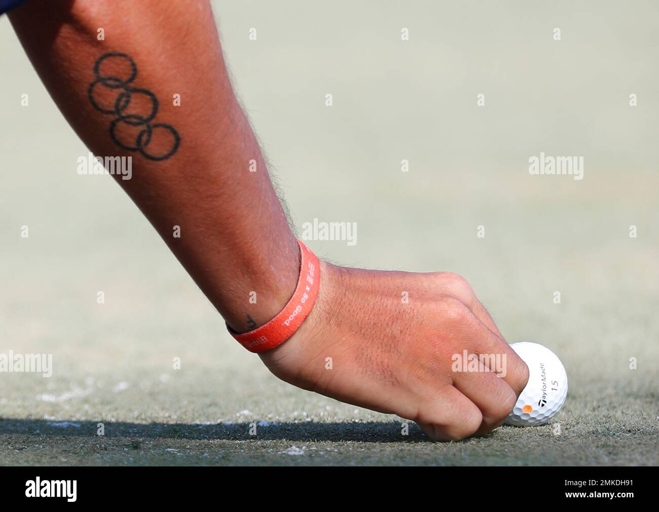 Rickie Fowler's Olympic tattoo is shown as he places his ball on the ...