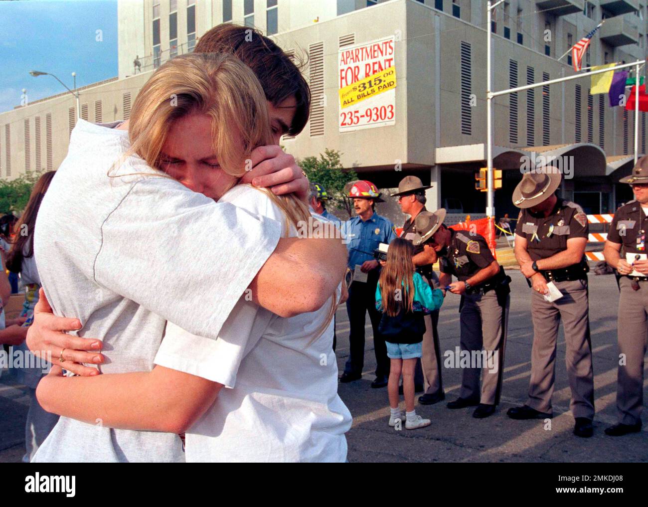 Dawn Greathouse and Jason Oliver embrace as a young community volunteer ...