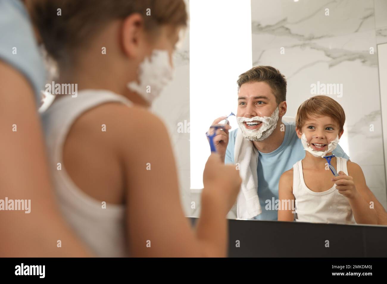 Dad shaving and son imitating him in bathroom Stock Photo - Alamy