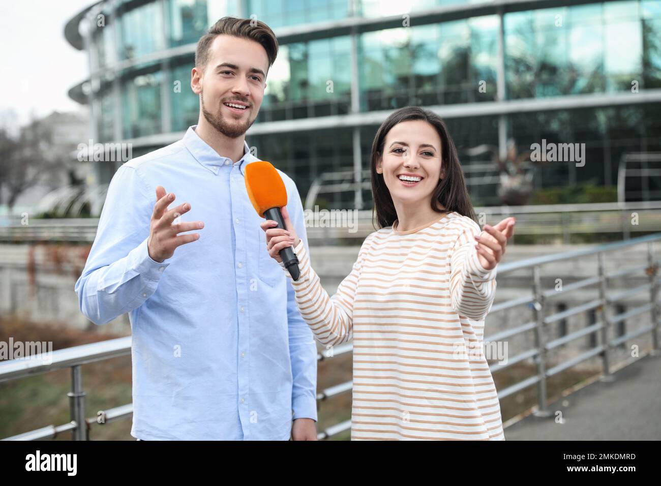 Young journalist interviewing man on city street Stock Photo - Alamy