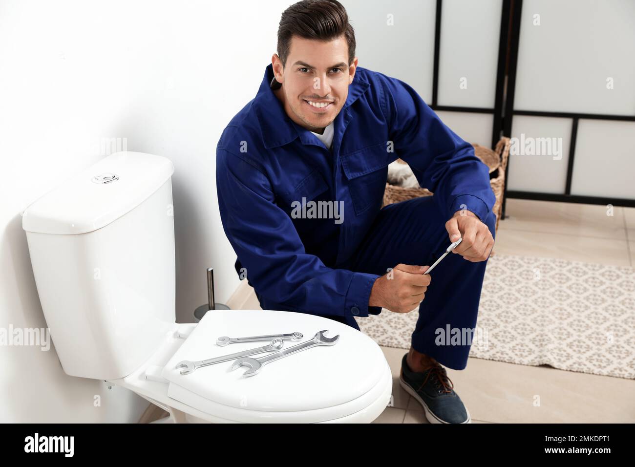 Professional plumber working with toilet bowl in bathroom Stock Photo ...