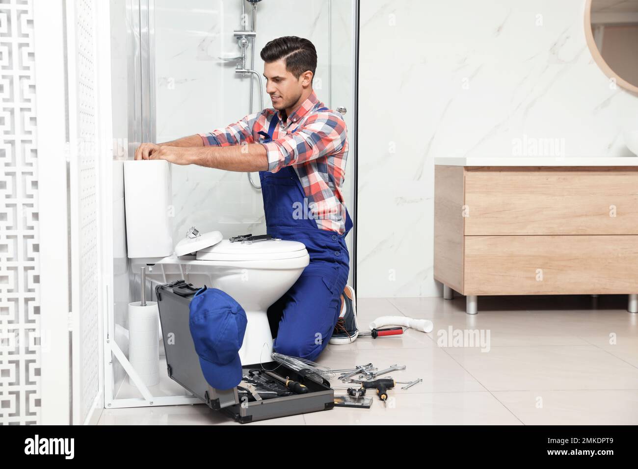 Professional plumber working with toilet bowl in bathroom Stock Photo ...