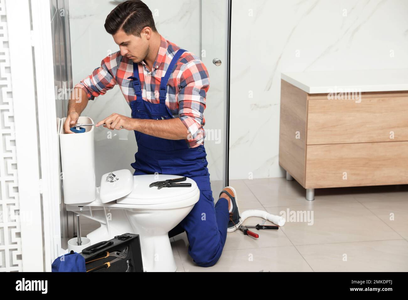 Professional plumber working with toilet bowl in bathroom Stock Photo ...