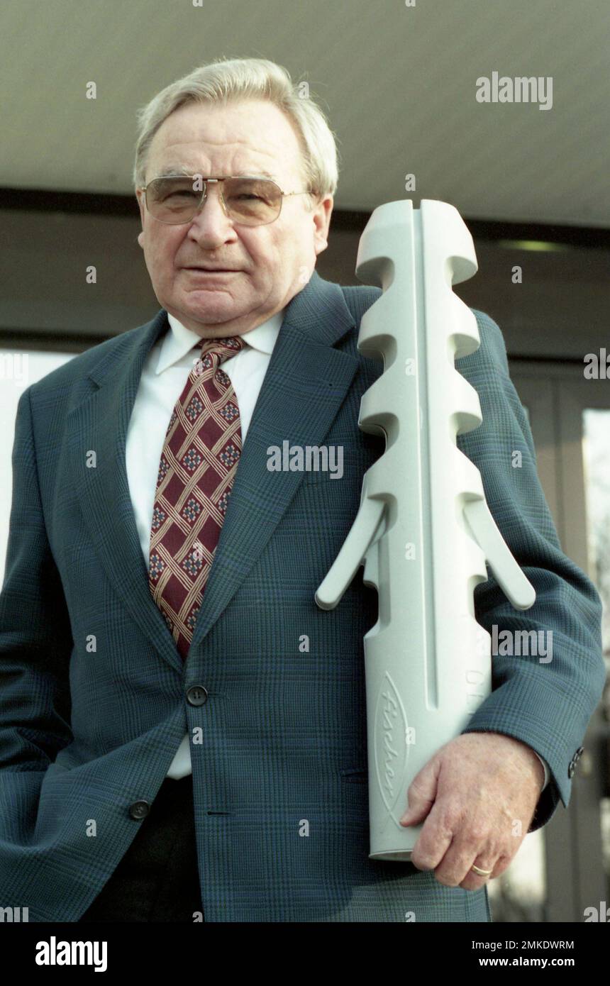 Artur Fischer, pictured holding an over sized model of his invention ...