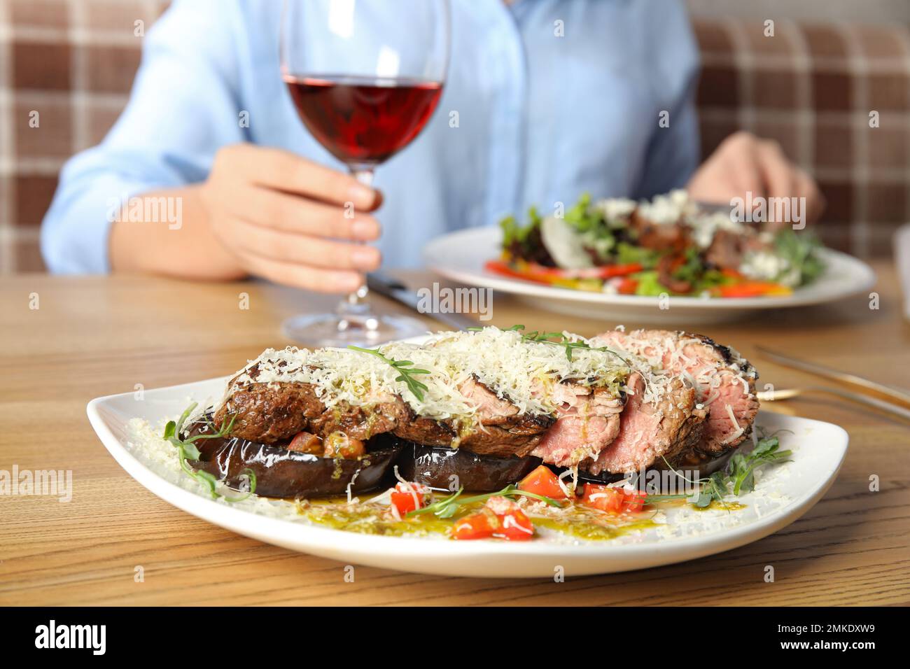 Delicious roasted meat and blurred woman on background Stock Photo - Alamy