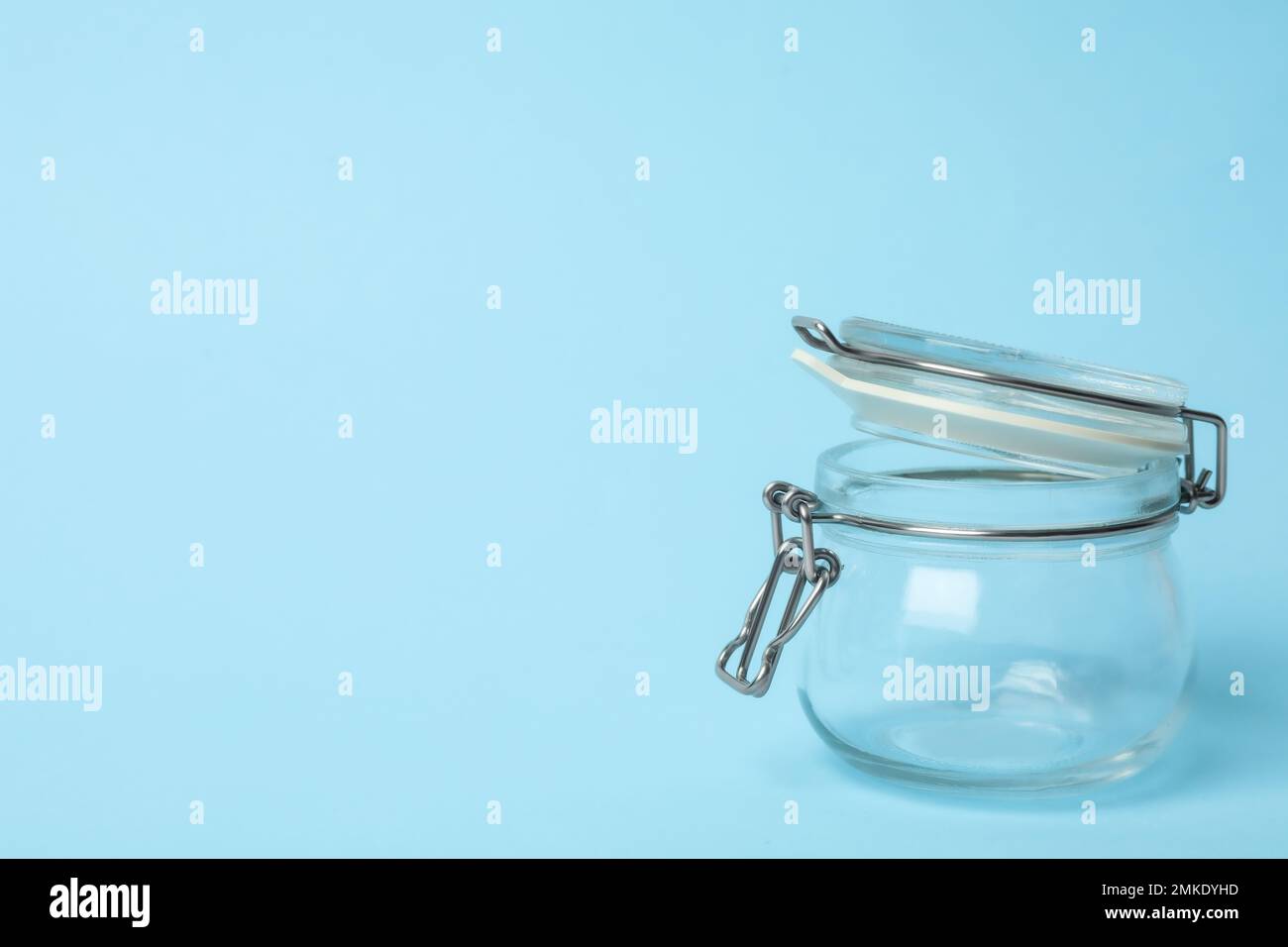 Open empty glass jar on light blue background, space for text Stock ...