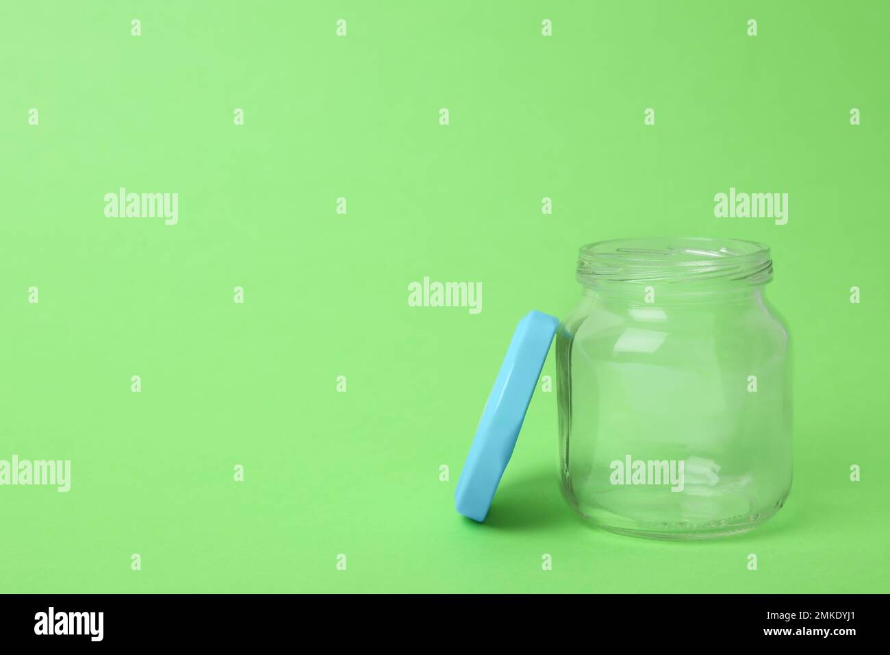 Open empty glass jar on light green background, space for text Stock ...