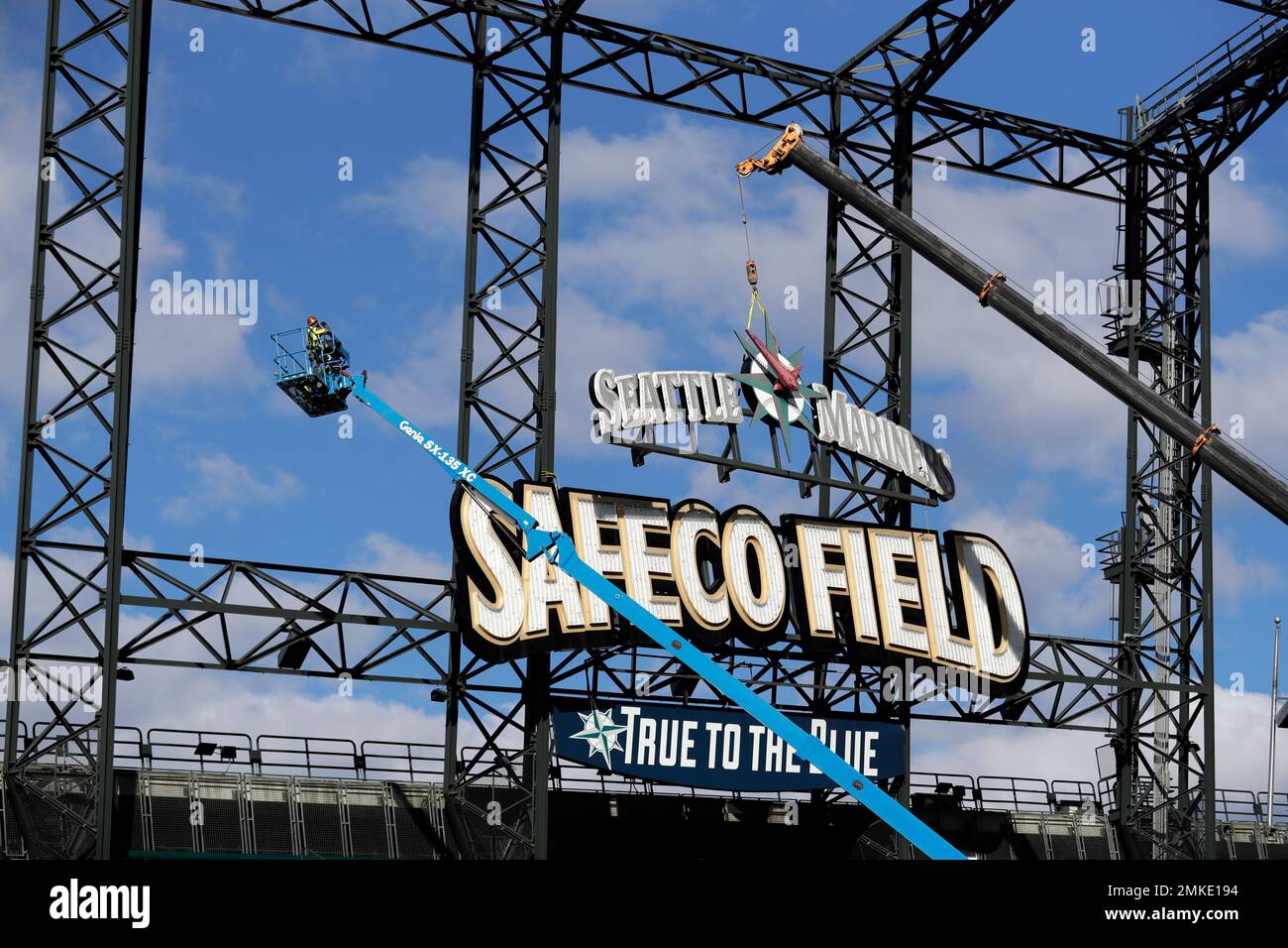 Workers look across from a boom lift as the Seattle Mariners' clock ...